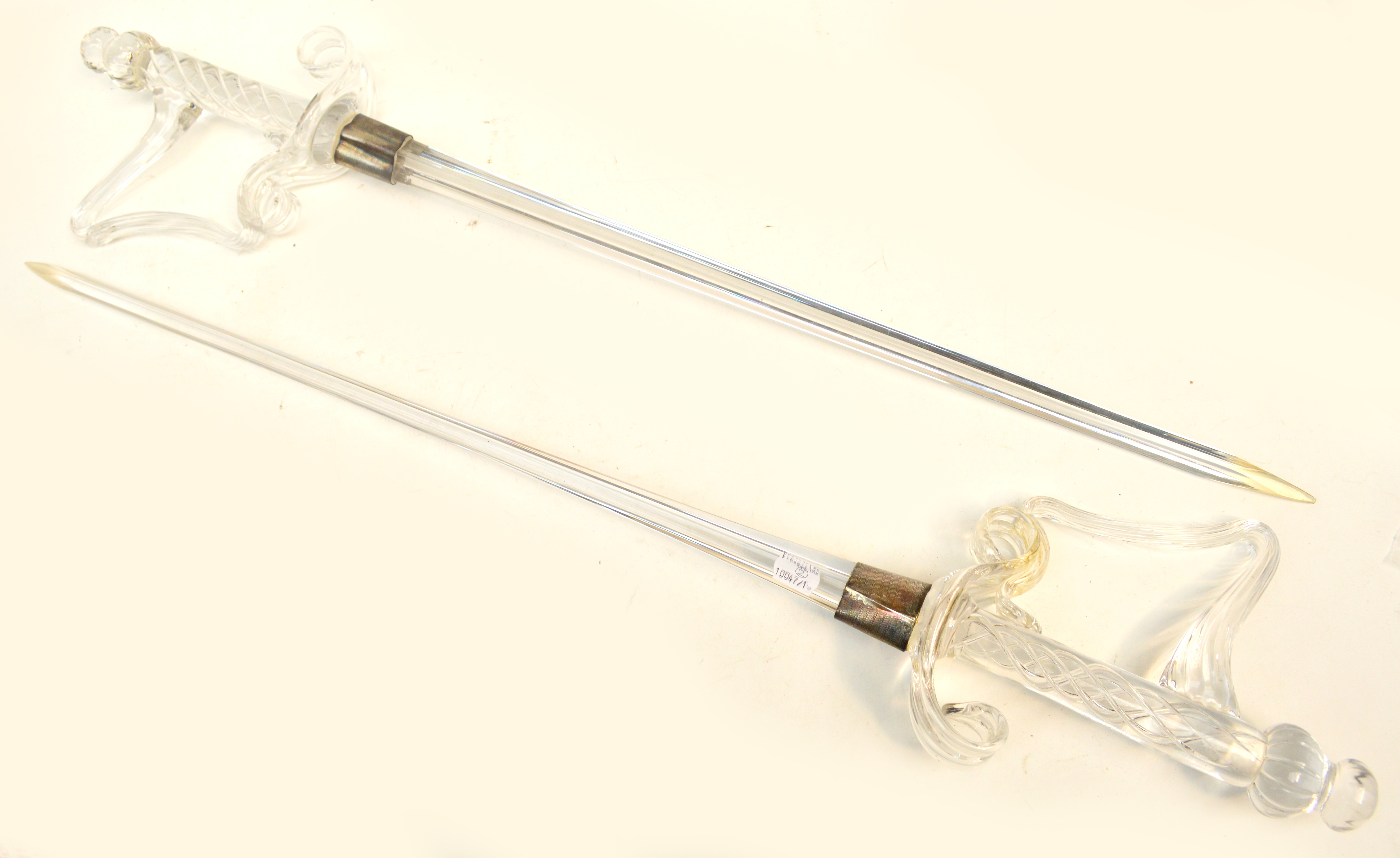 A pair of Irish clear glass swords with air twist grip and scroll hilt ...