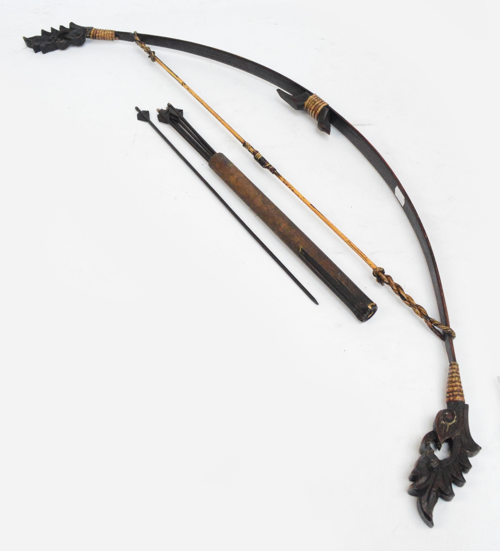 An African tribal carved wooden bow with a small quiver of five arrows ...