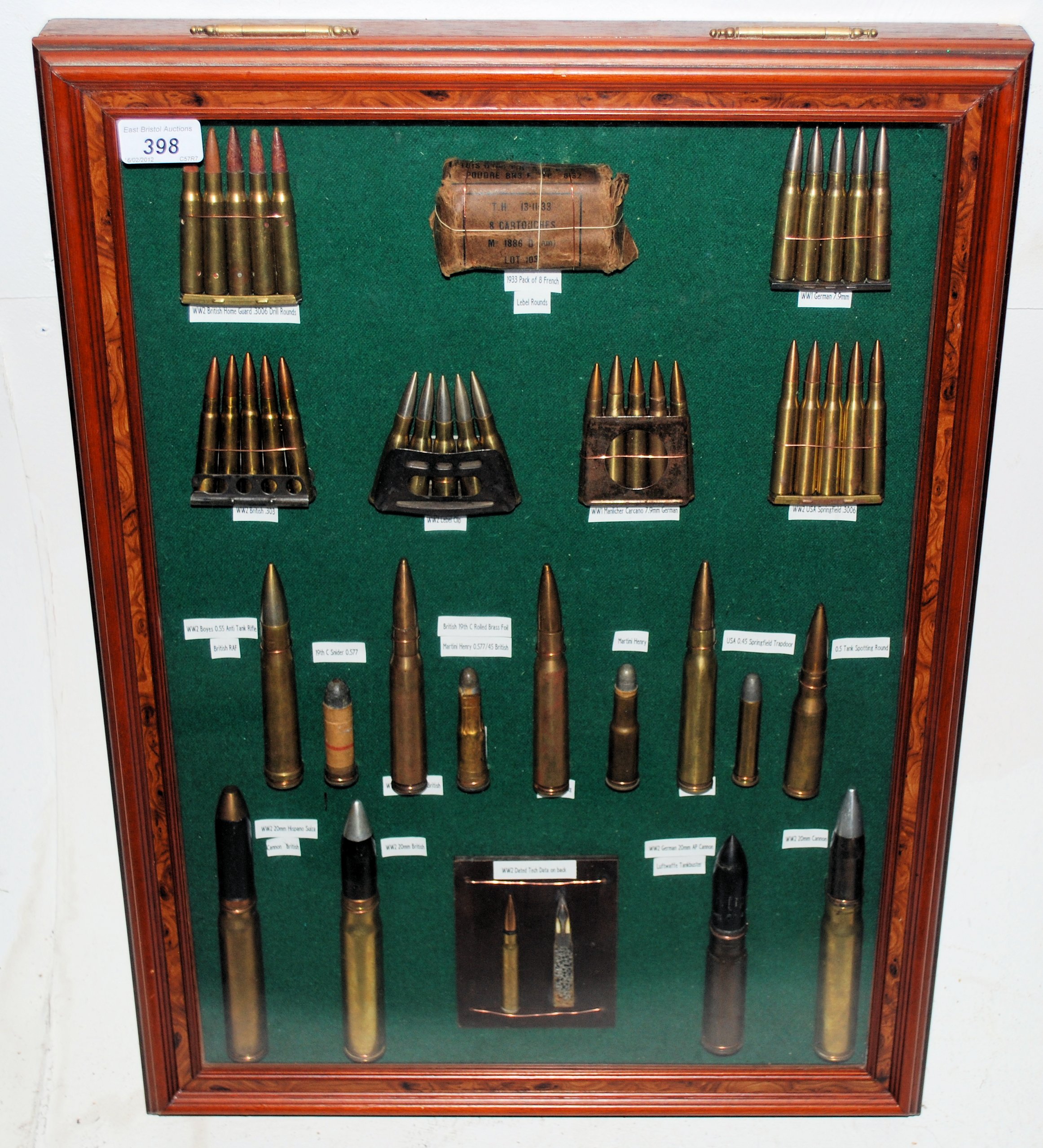 A glass fronted hanging display cabinet of inert ammunition from pistol ...