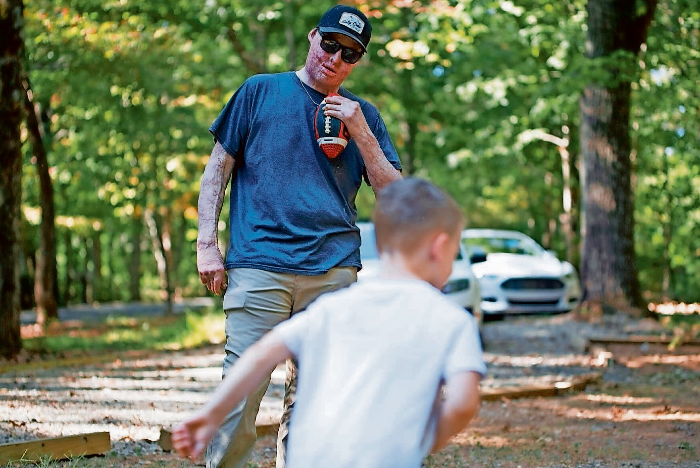 Riley Draper plays football with his son, Bentley, 5, in their front ...