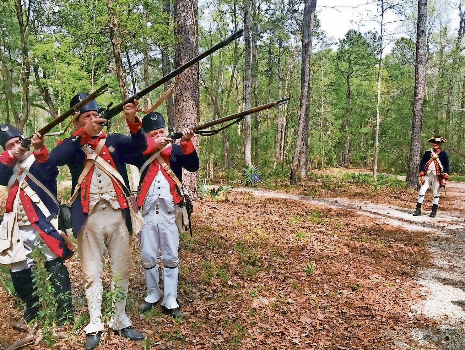 revolutionary war reenactors demonstrate their weapons during part of a ...